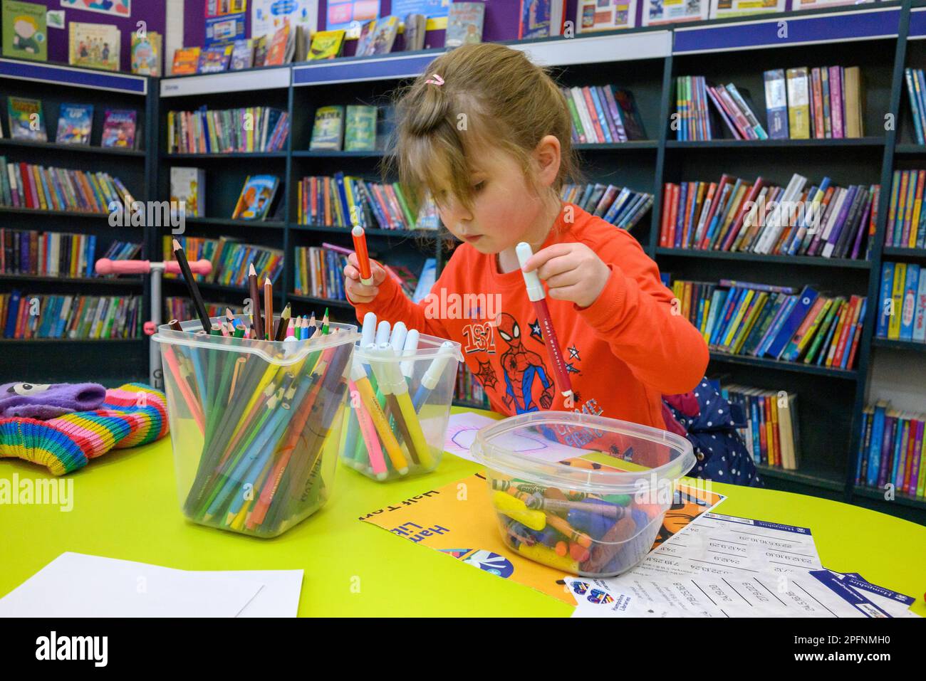 Child in a library being creative drawing with pens and pencils Stock ...