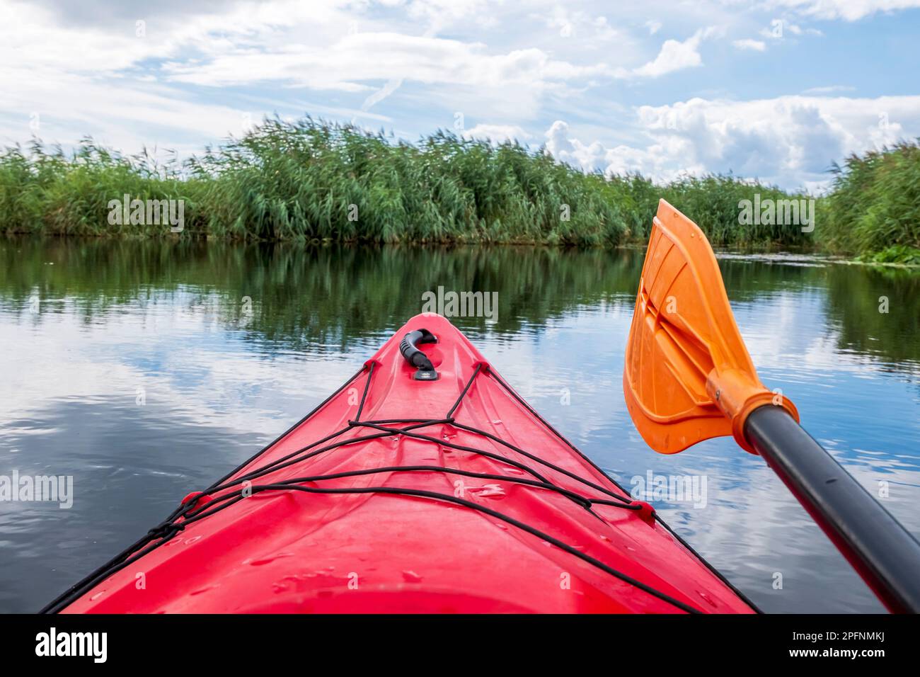 Kayaker point of view. Red kayak bow with a view on the river and ...