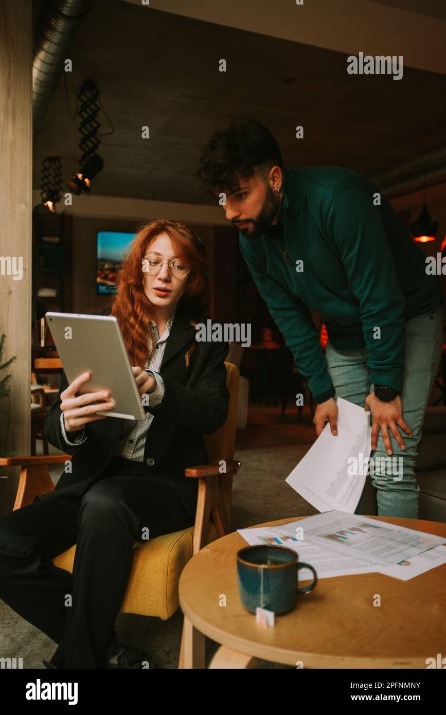 A good looking male business person looking at the tablet while his ...