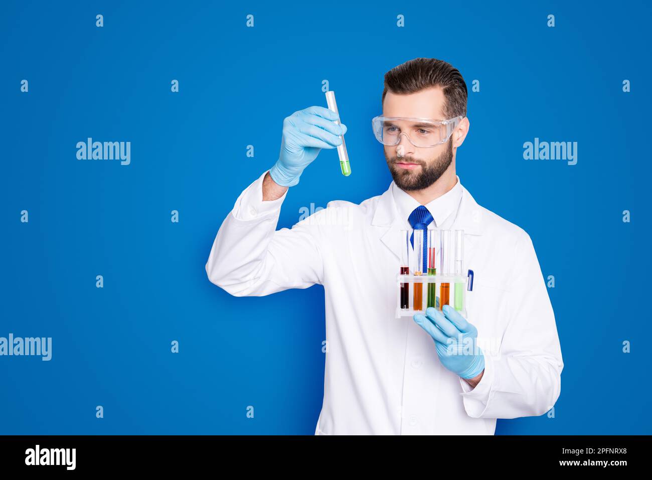 Portrait of busy concentrated scientist with stubble in white lab coat ...