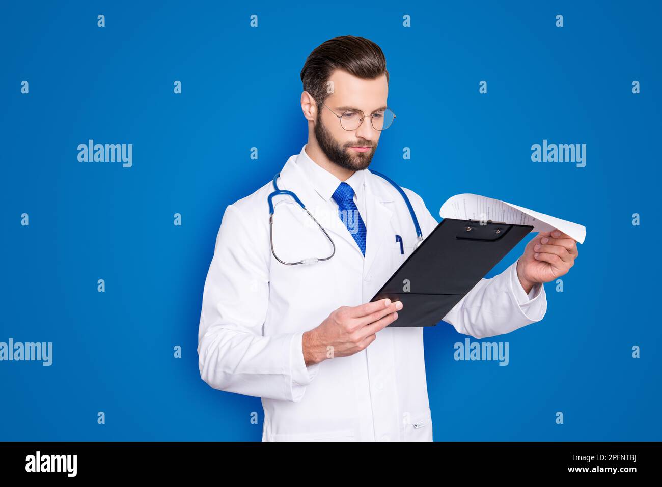 Portrait of concentrated busy doc in white lab coat and stethoscope on ...