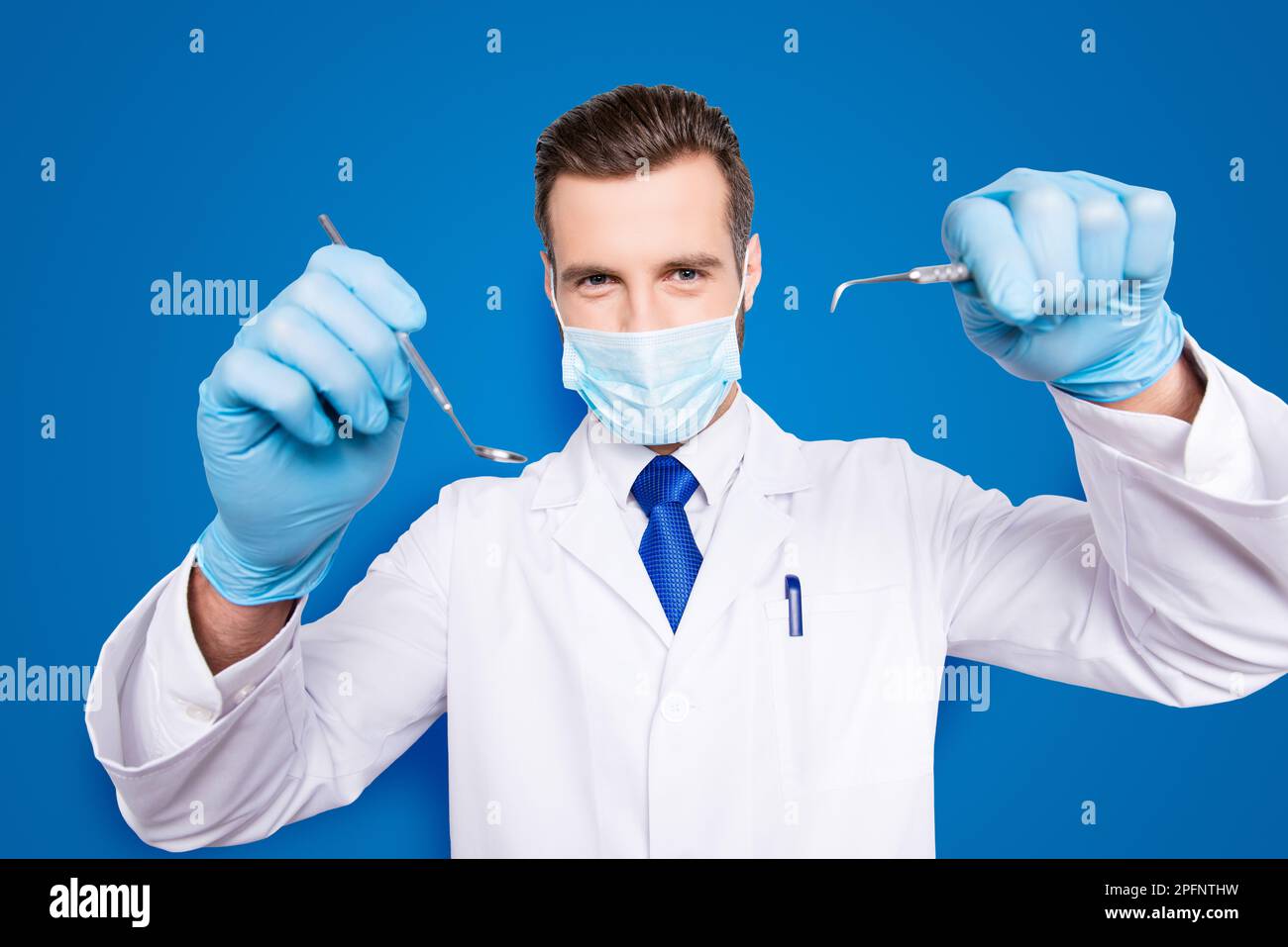 Portrait of attractive hjandsome dentist in white lab coat, blue tie in ...