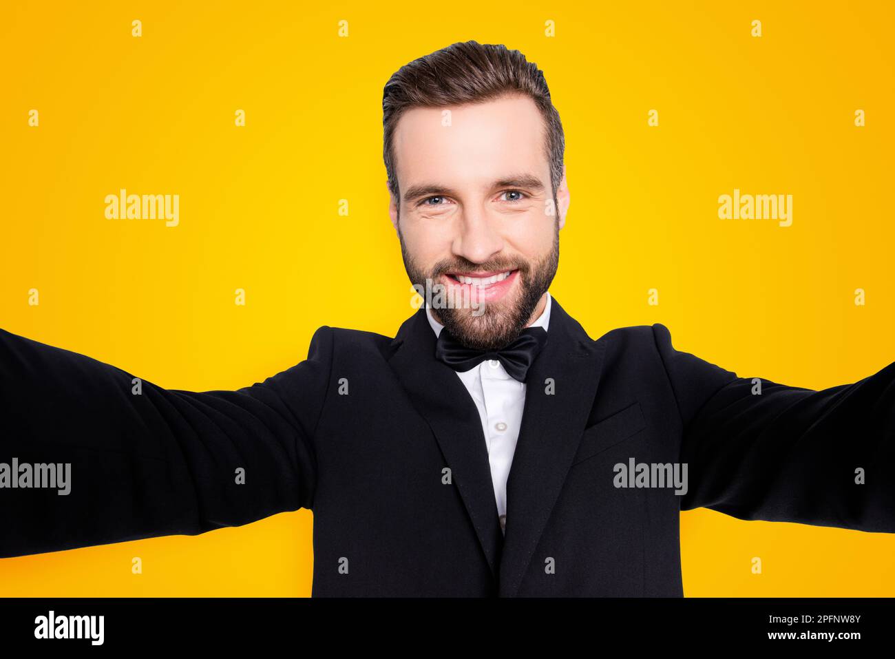 Self portrait of stylish cheerful artist in black suit with bowtie ...