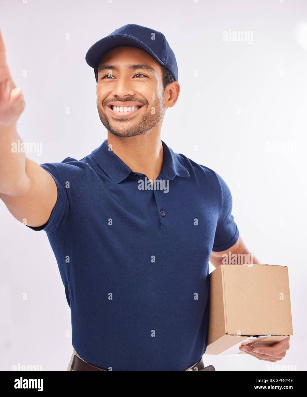 Delivery man, shipping box and smile of a employee in studio with ...
