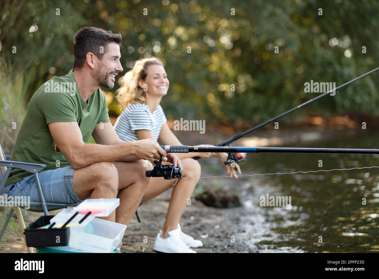 man and woman fishing from the river-bank Stock Photo - Alamy
