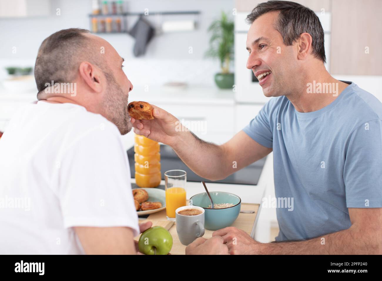young gay couple having breakfast in the kitchen Stock Photo - Alamy