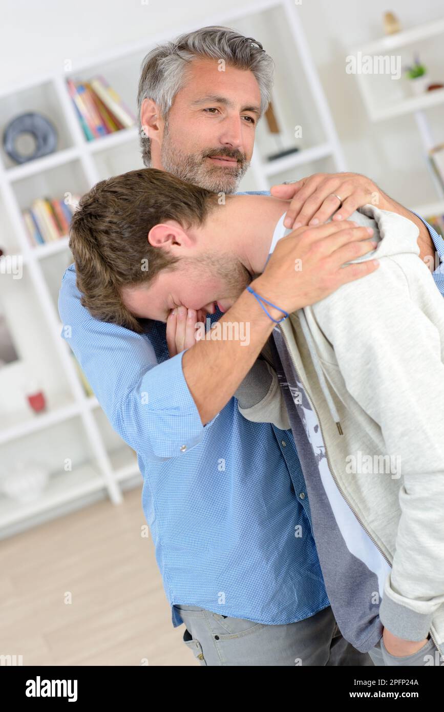 a father hugging young man crying Stock Photo - Alamy