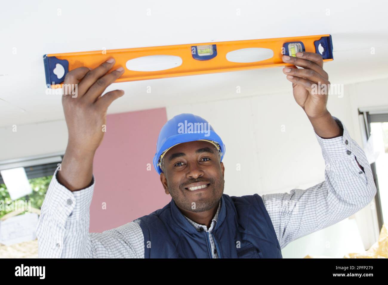 builder taking measures with spirit level on the ceiling Stock Photo ...