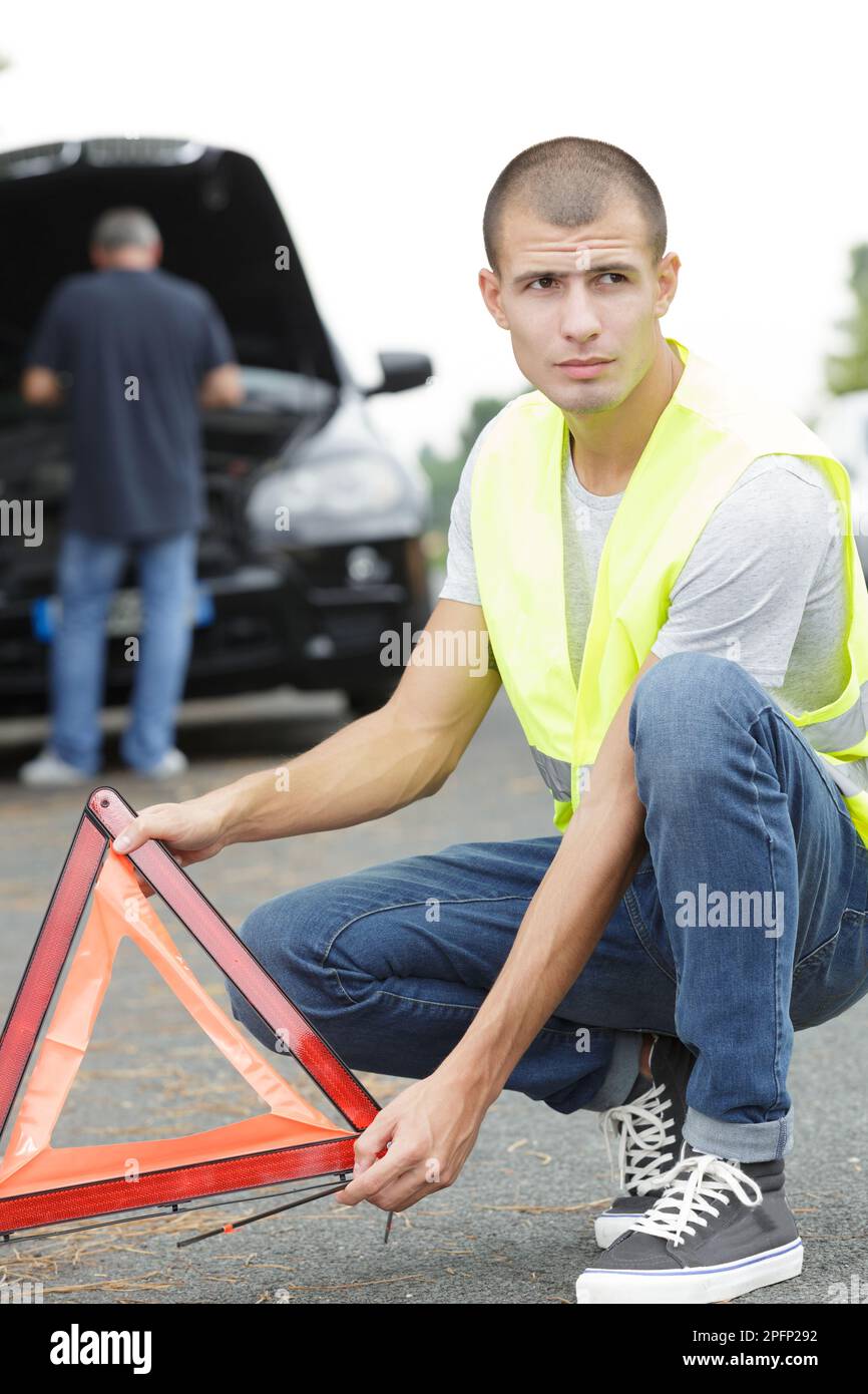 driver putting out a traffic warning sign Stock Photo - Alamy