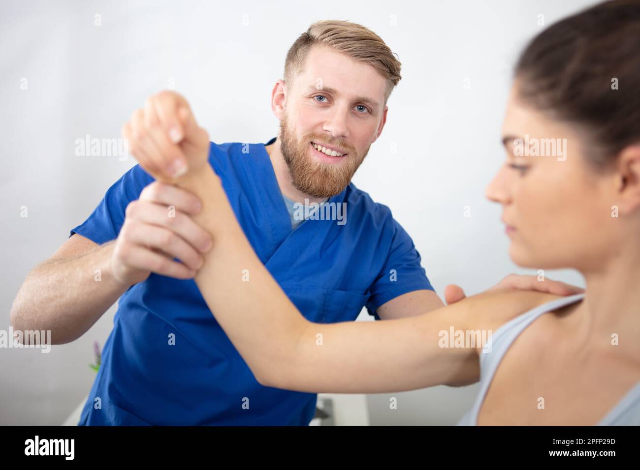 handsome physiotherapist treating patients shoulder Stock Photo - Alamy