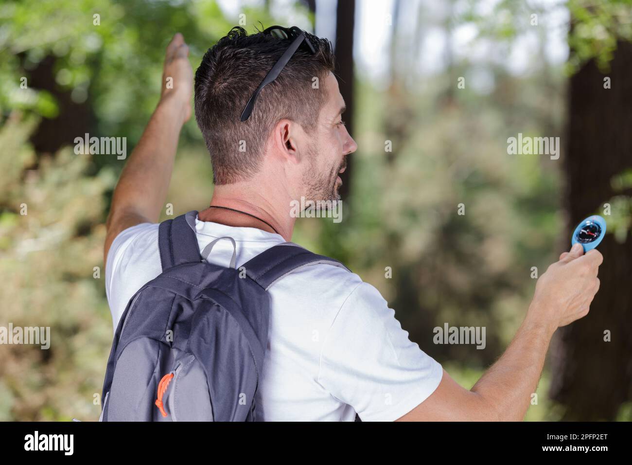 man with backpack orienteering using compass Stock Photo - Alamy