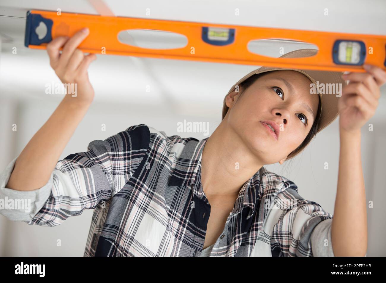 happy woman measuring level of ceiling Stock Photo - Alamy