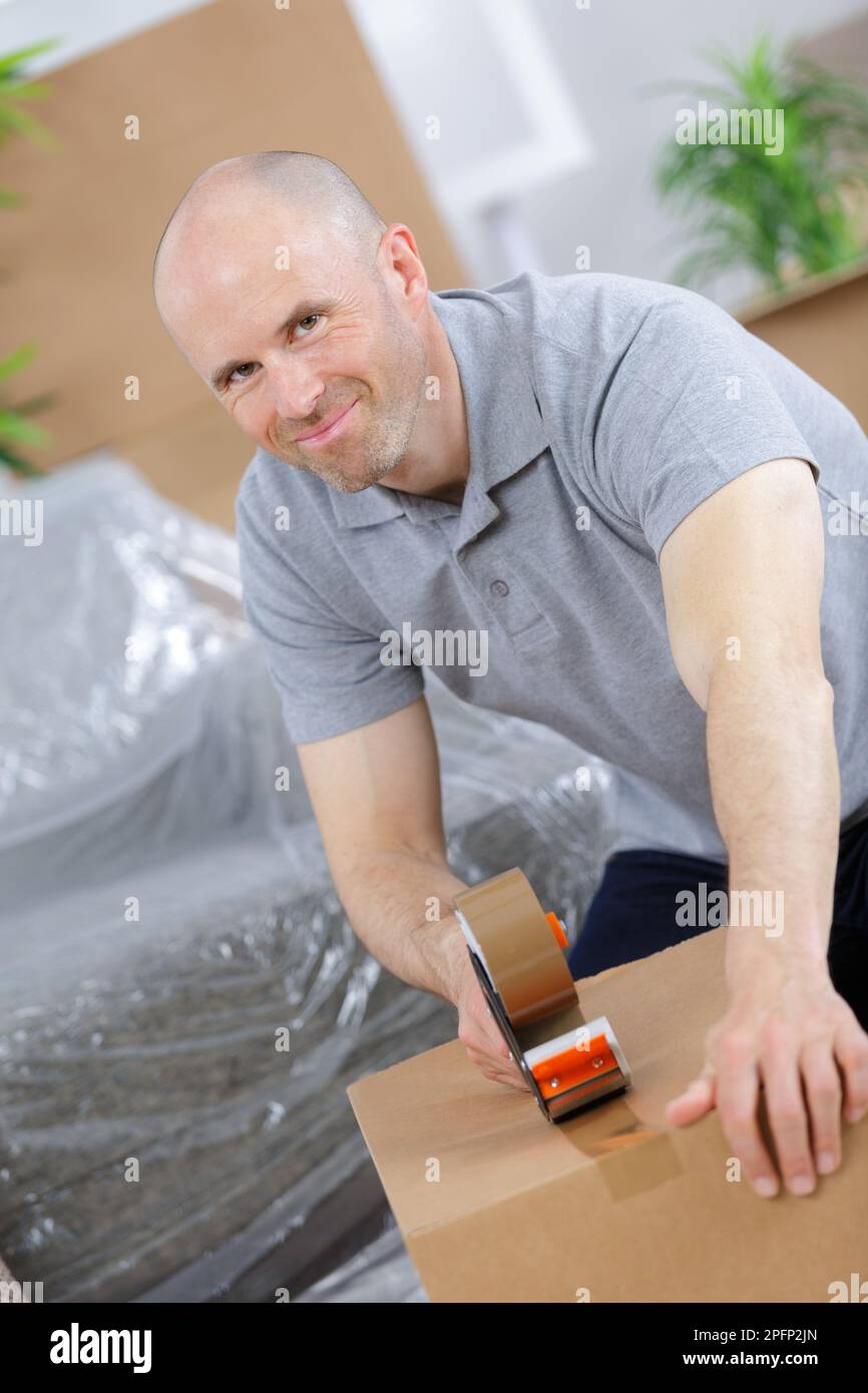 Caucasian man taping cardboard box hi-res stock photography and images ...