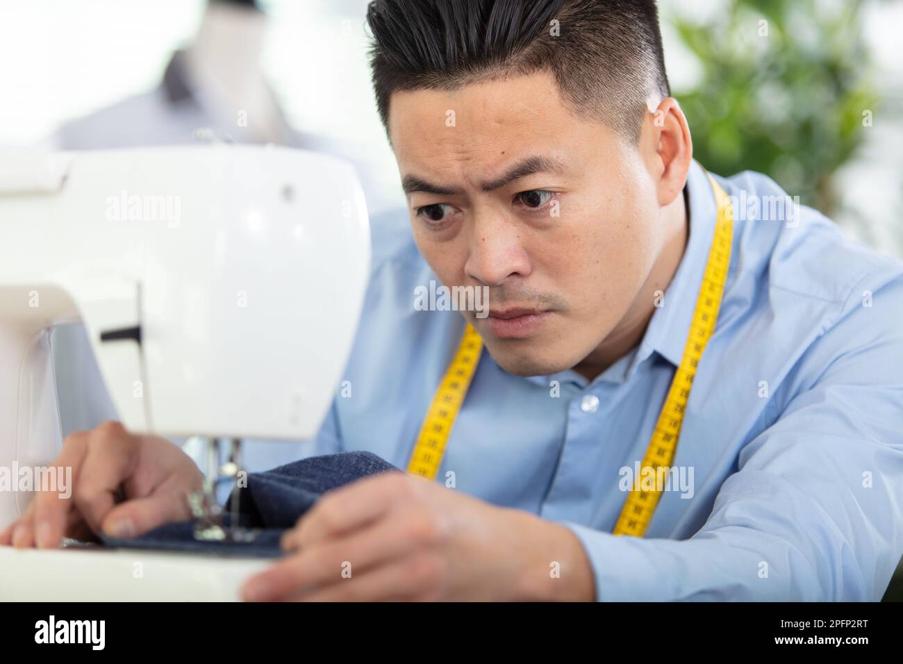 man sewing with a sewing machine in his workshop Stock Photo - Alamy