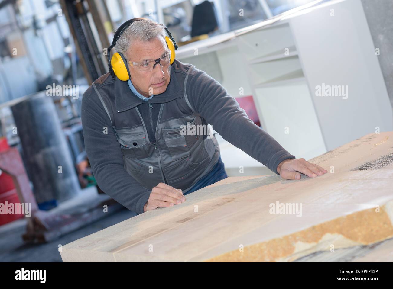 mid adult carpenter using tablesaw to cut wood in workshop Stock Photo ...