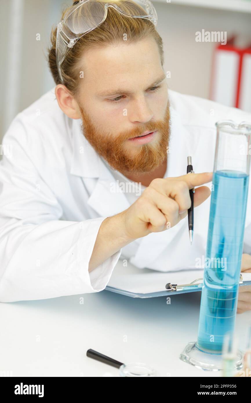 leasant male biologist holding a test tube in a lab Stock Photo - Alamy