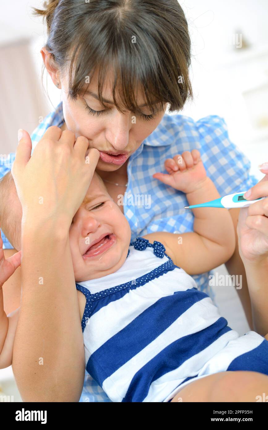 a crying baby with her mum Stock Photo - Alamy