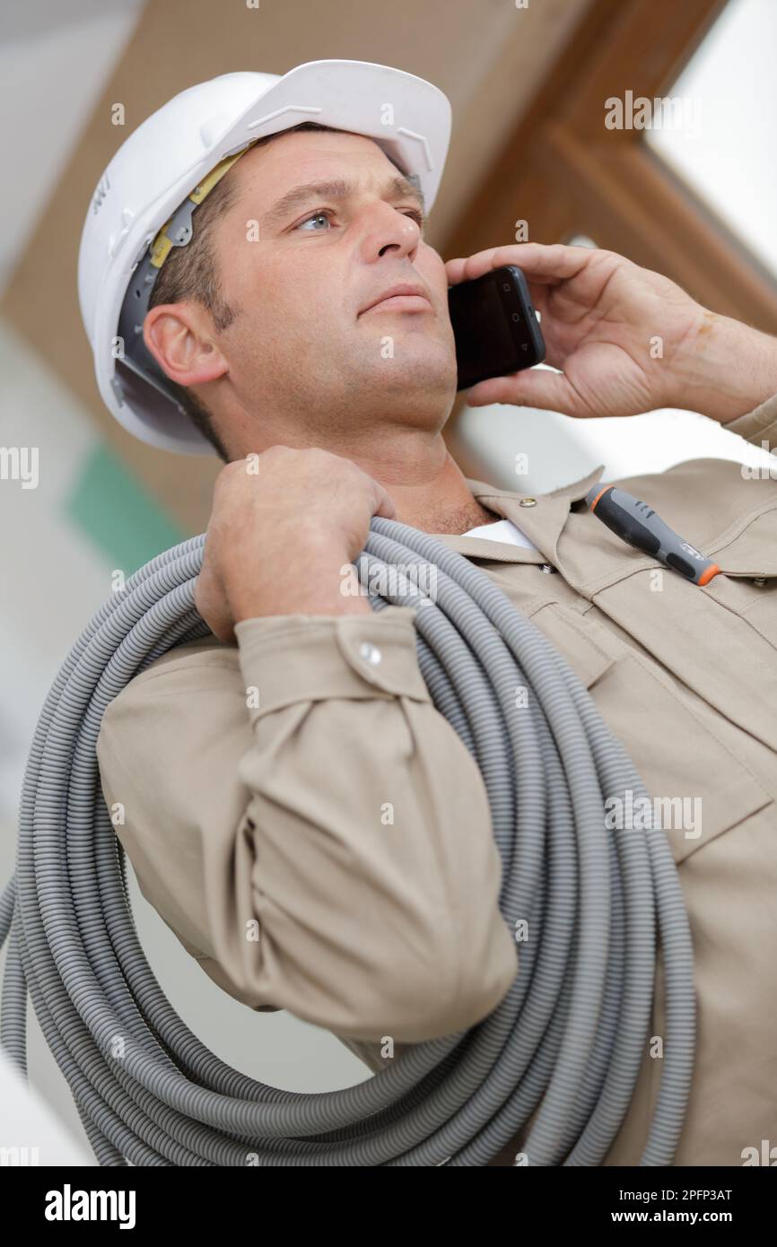 low-angle view of construction worker using telephone Stock Photo - Alamy
