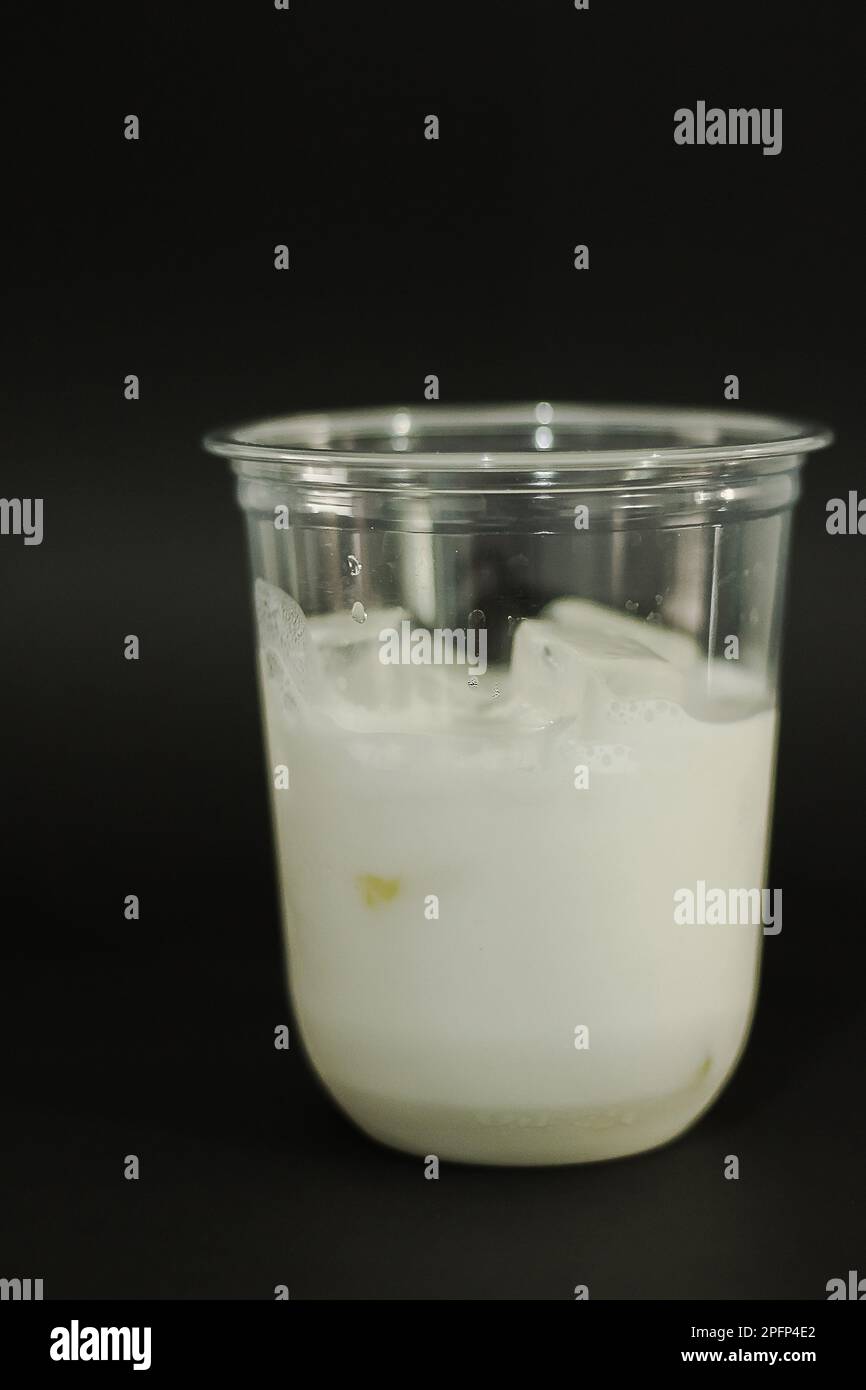 Milk and ice cubes in a plastic glass on a black background Stock Photo ...