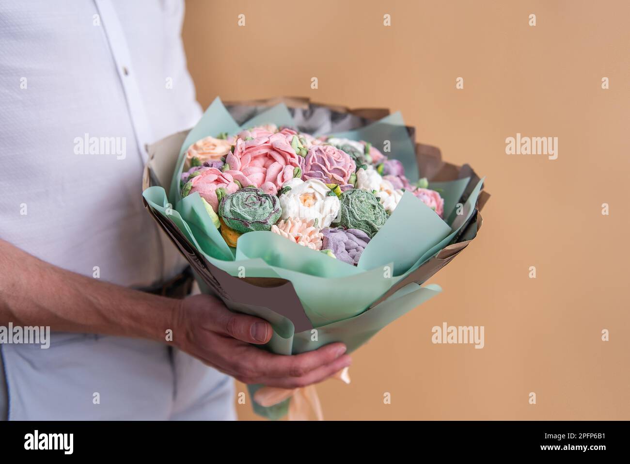 Faceless man holds bouquet of marshmallow sweet flowers in hands. Gift ...