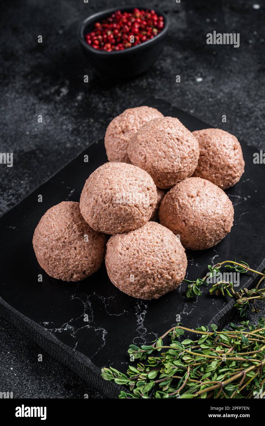 Raw vegan meatballs from plant based meat with thyme. Black background ...
