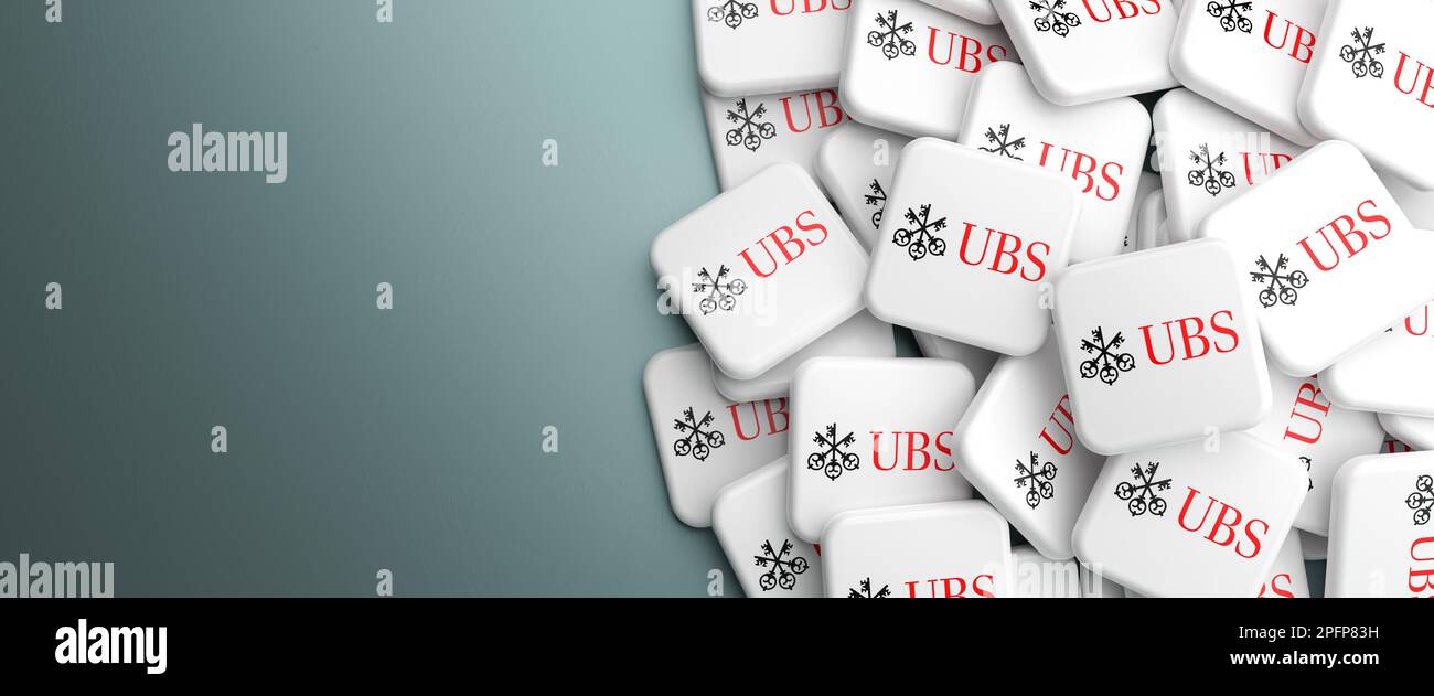 Logos of Swiss UBS bank on a heap on a table. Copy space. Web banner ...