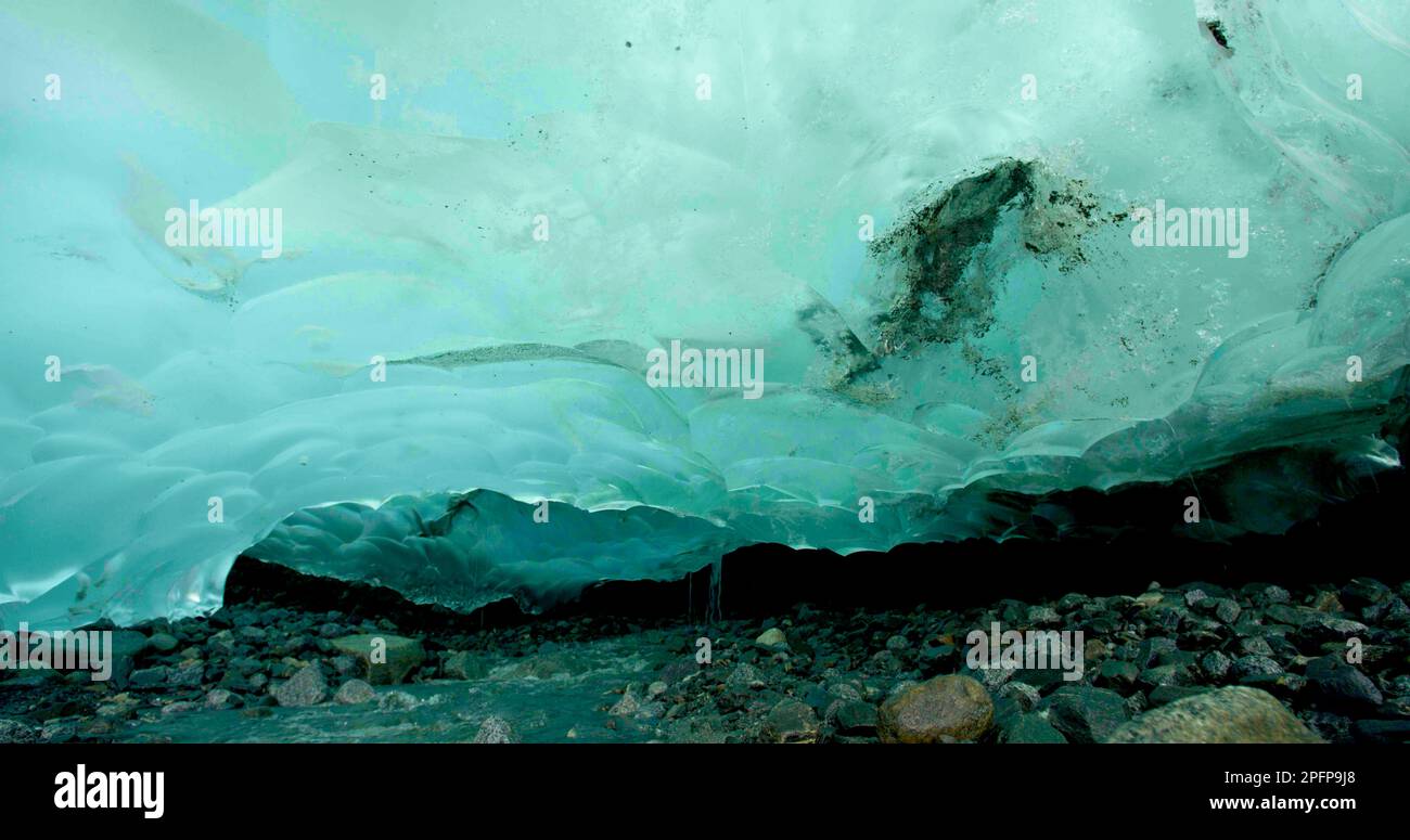 The ice under the rocks gradually melts and forms rivers. Turquoise ice ...