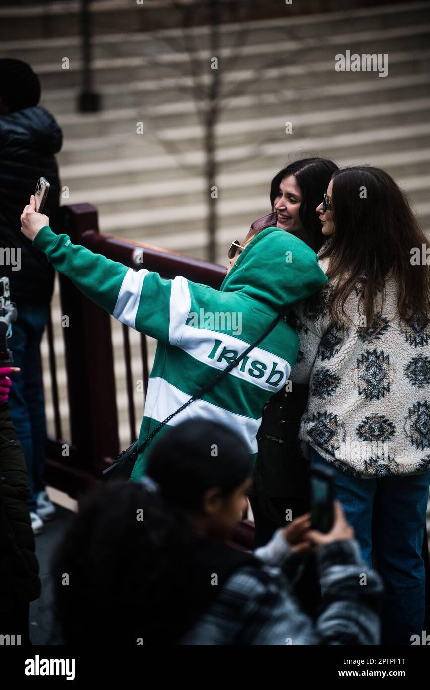 A group of people taking photos on the street in Chicago during Saint ...