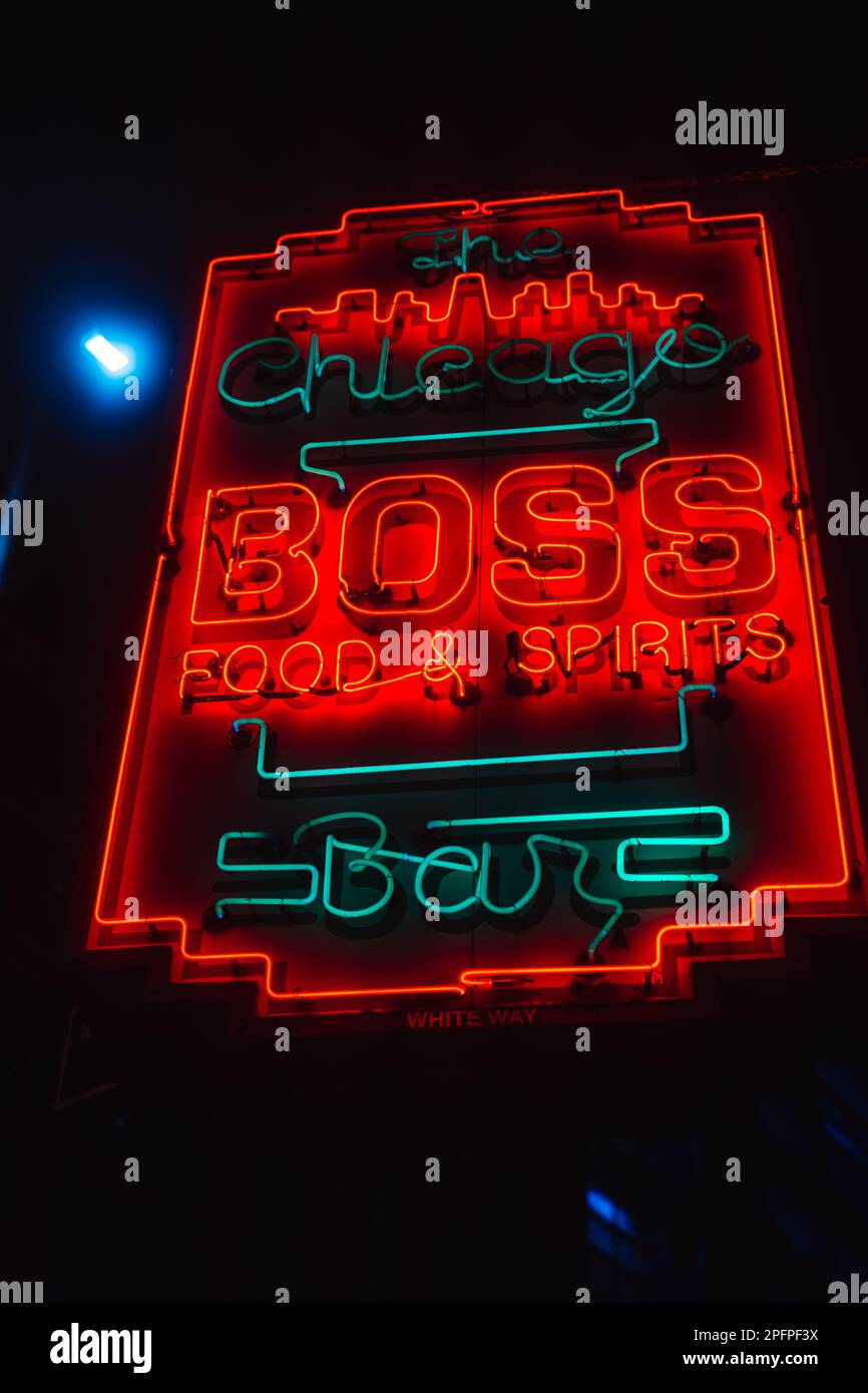 A glowing neon sign 'Boss' mounted on a brick building advertising a ...