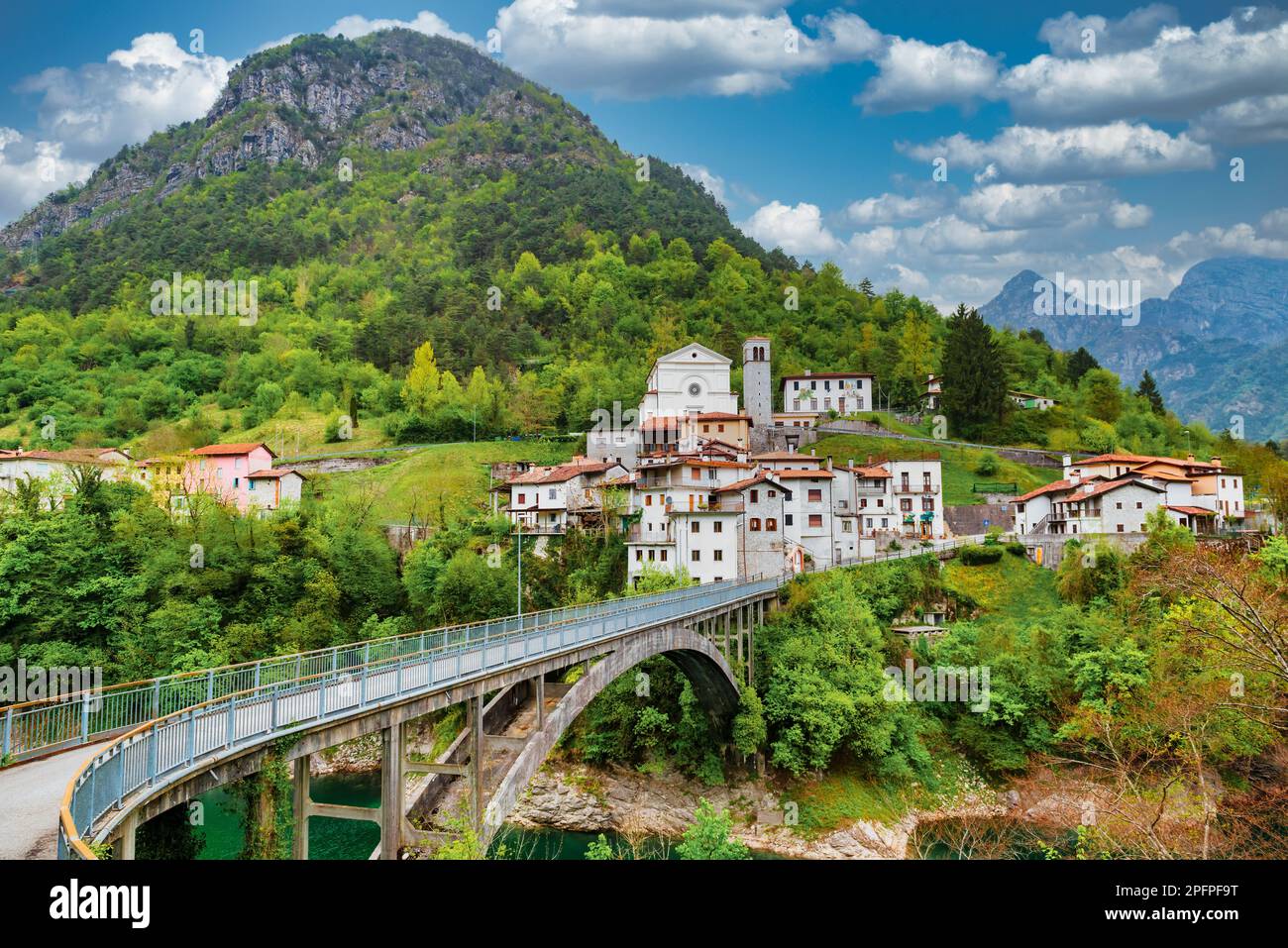 Scenic alpine village in Pordenone, Italy. Arc bridge and old houses on ...