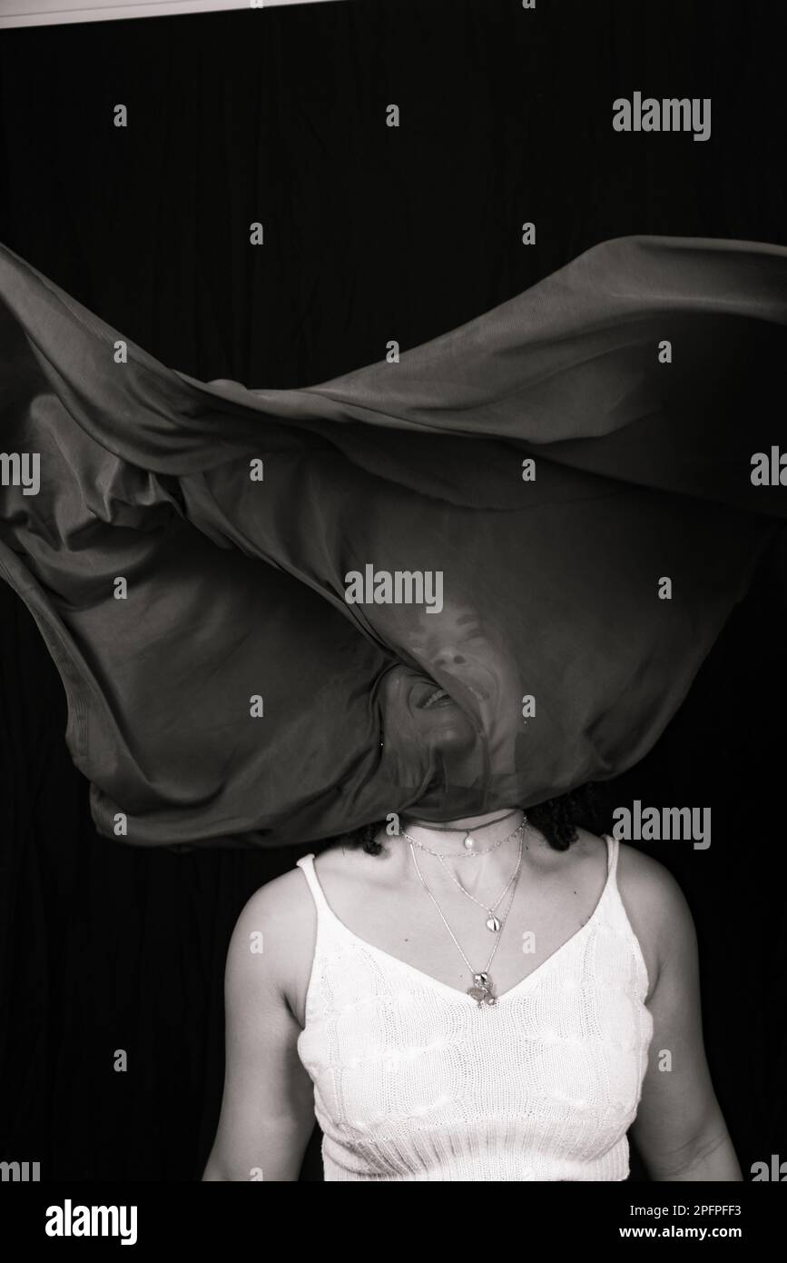 Black and white portrait of woman throwing cloth in the air. Isolated ...