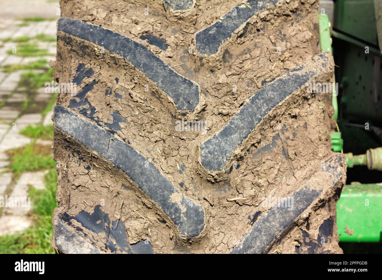 Dirty tire of a large tractor covered in mud after ploughing work on ...