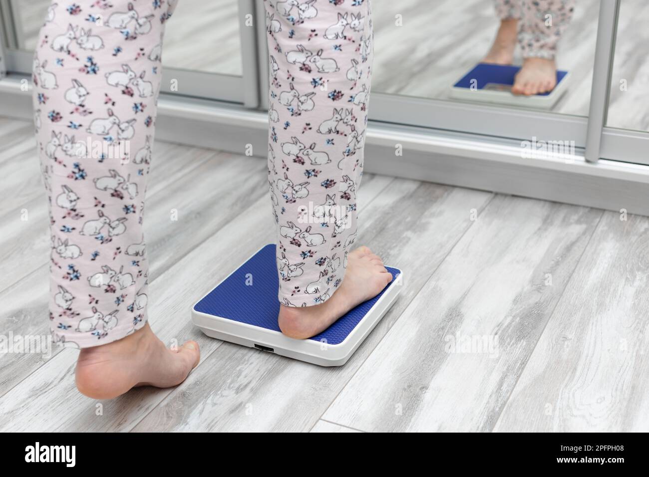woman stepping on the scales to control her weight. measuring a person ...