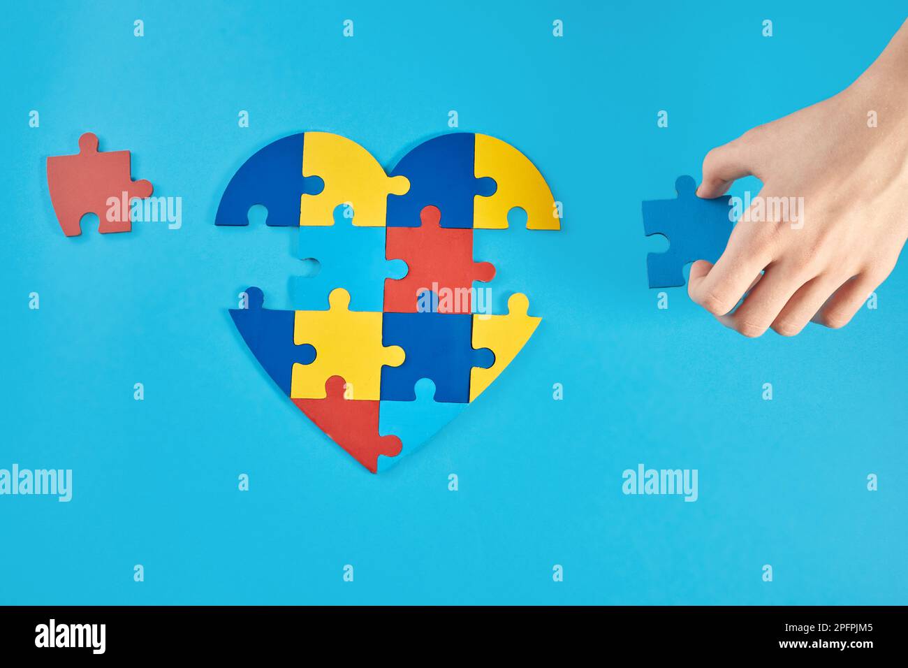 Autistic boy hands holding jigsaw puzzle heart shape. Autism spectrum ...