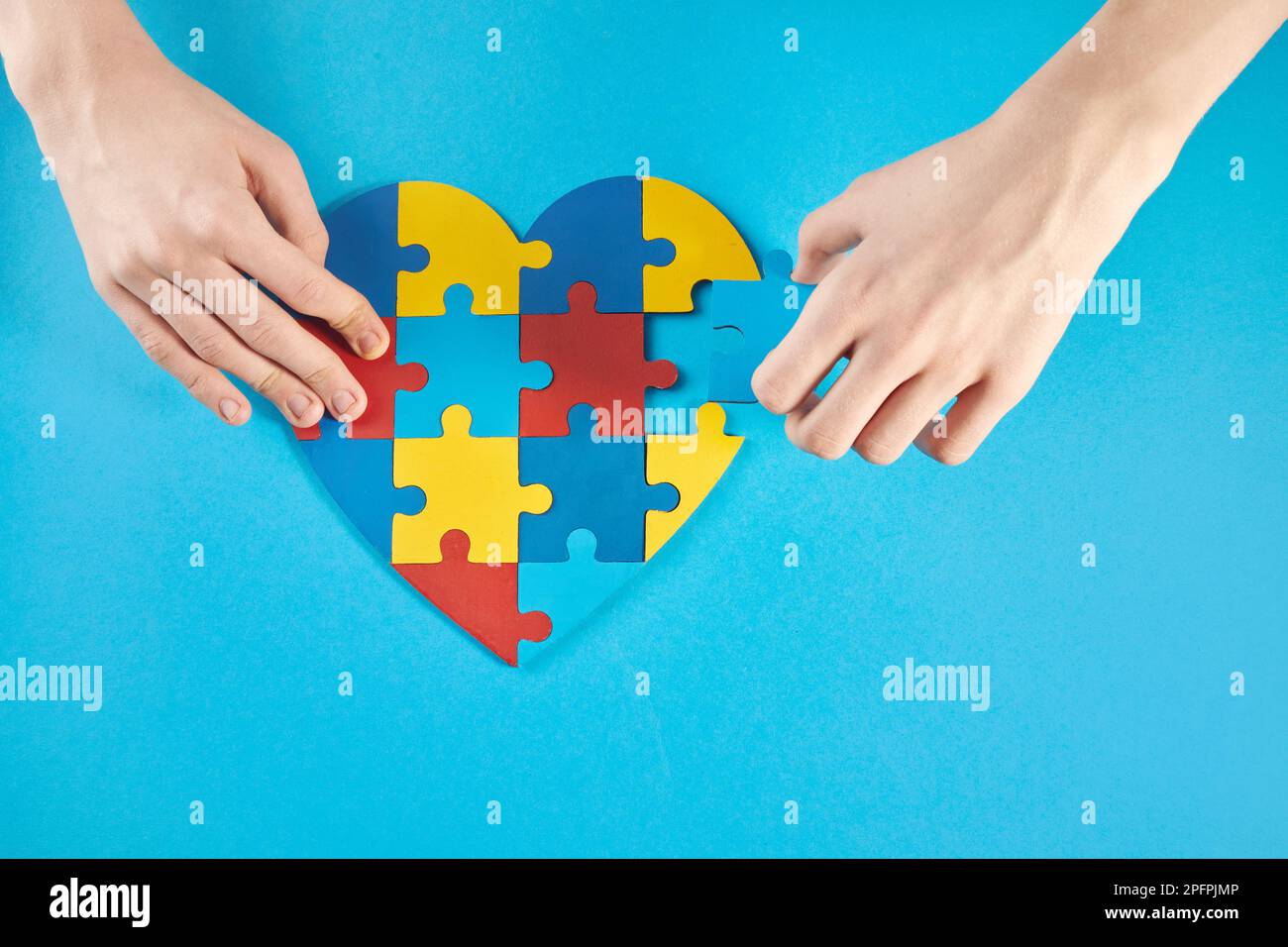 Autistic boy hands holding jigsaw puzzle heart shape. Autism spectrum ...