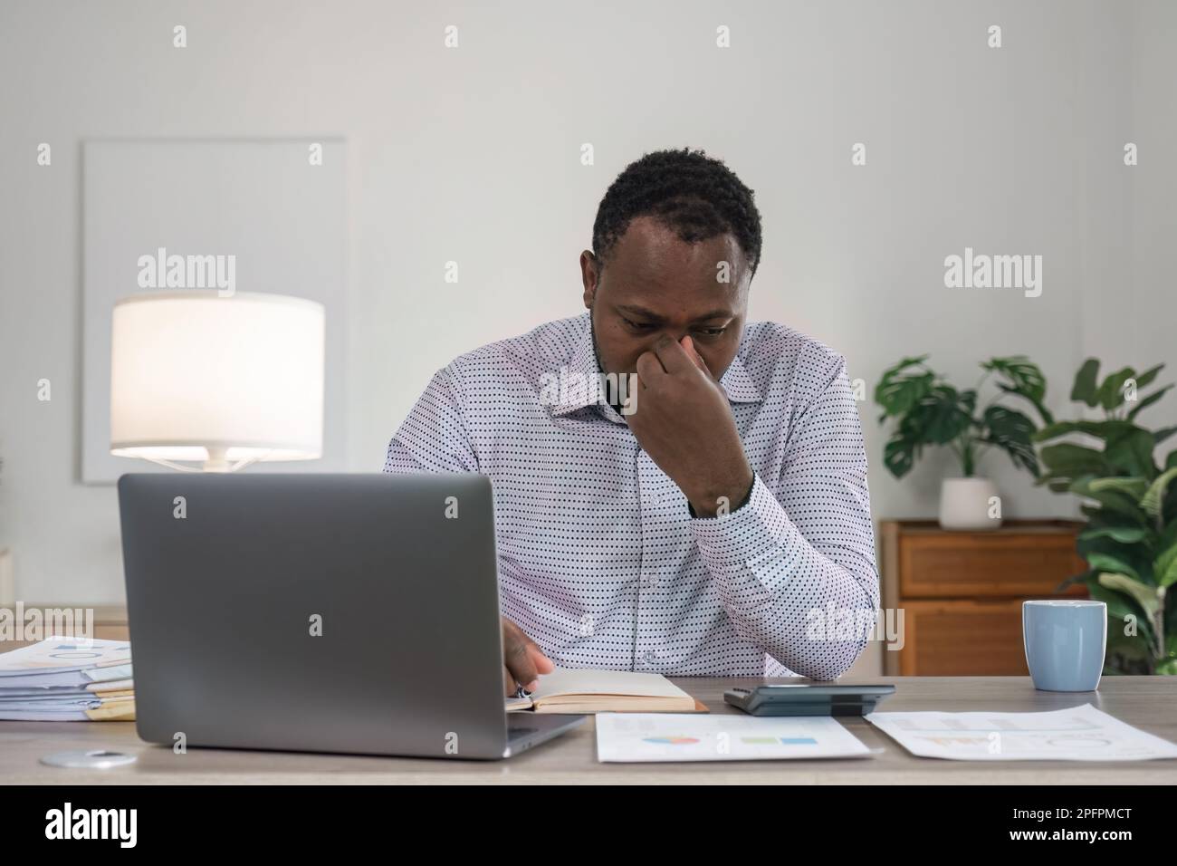 Stressed business man sitting at office workplace. Tired and overworked ...