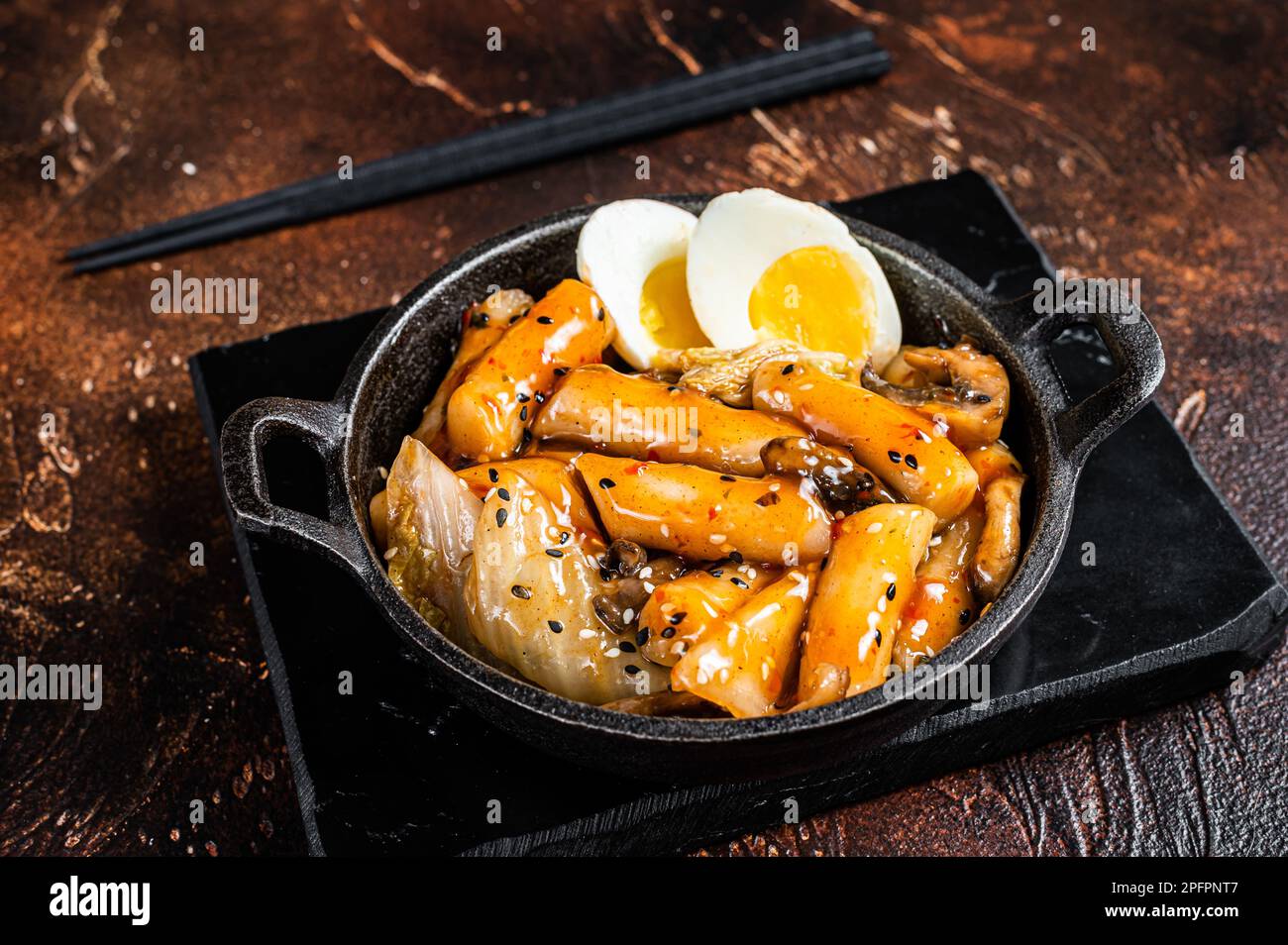 Korean Topokki or Tteokbokki rice cake with egg and mashrooms. Dark ...