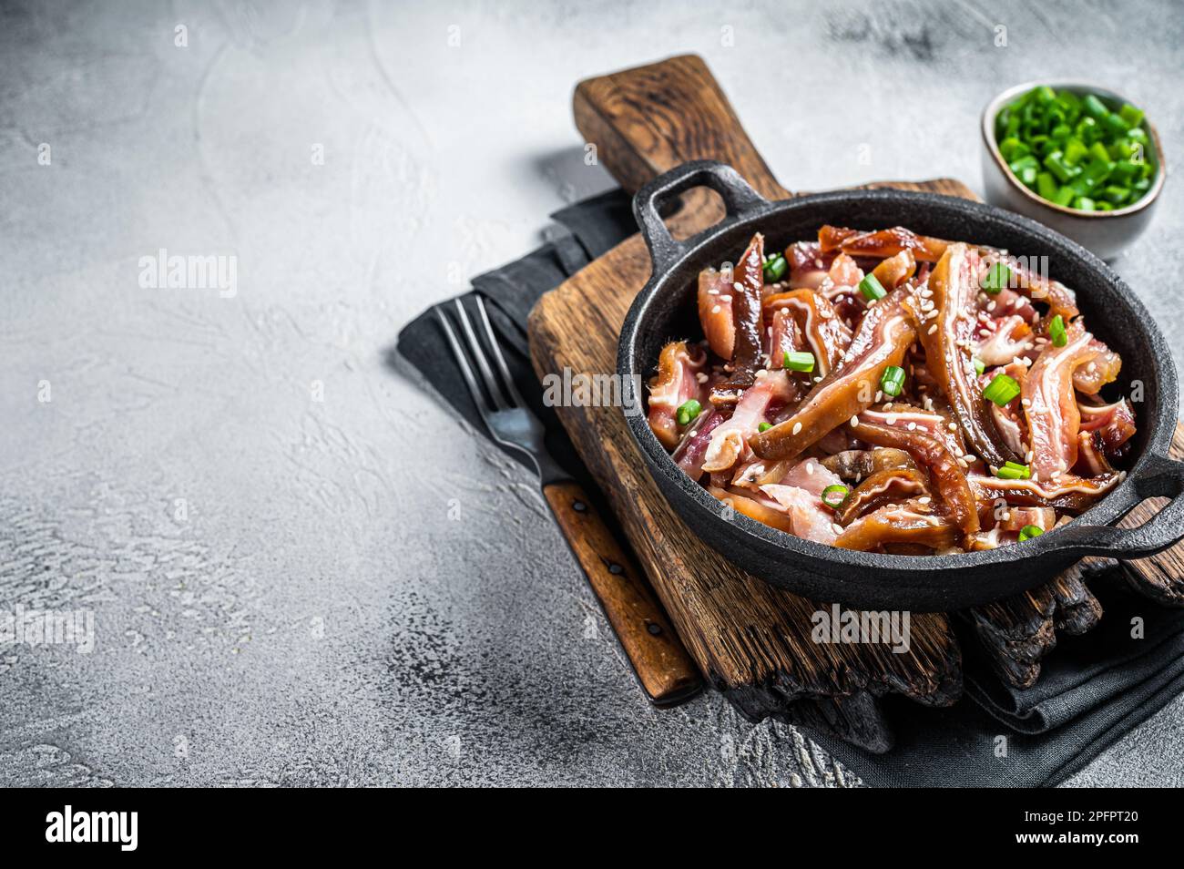 Fried spicy pork pig ears served in a frying pan. white background. Top ...