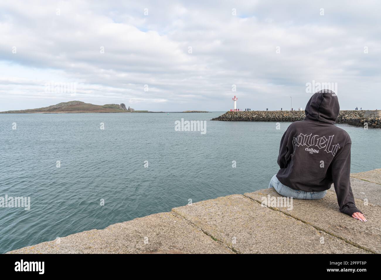 Person looking at the Howth Lighthouse on the East Pier from the West ...