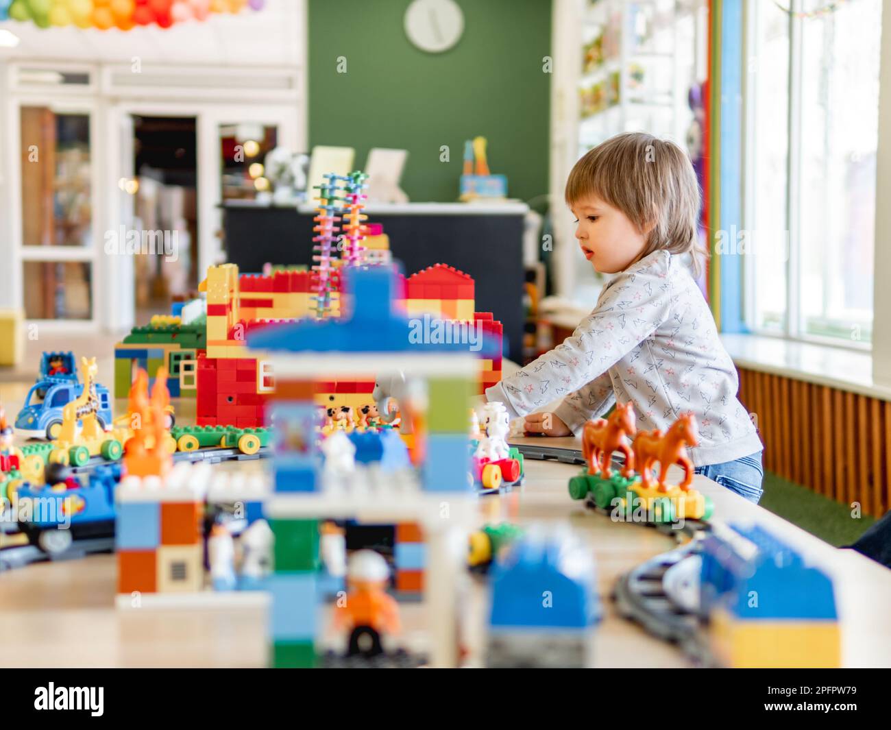 Toddler plays with colorful toy blocks. Little boy stares on figure ...
