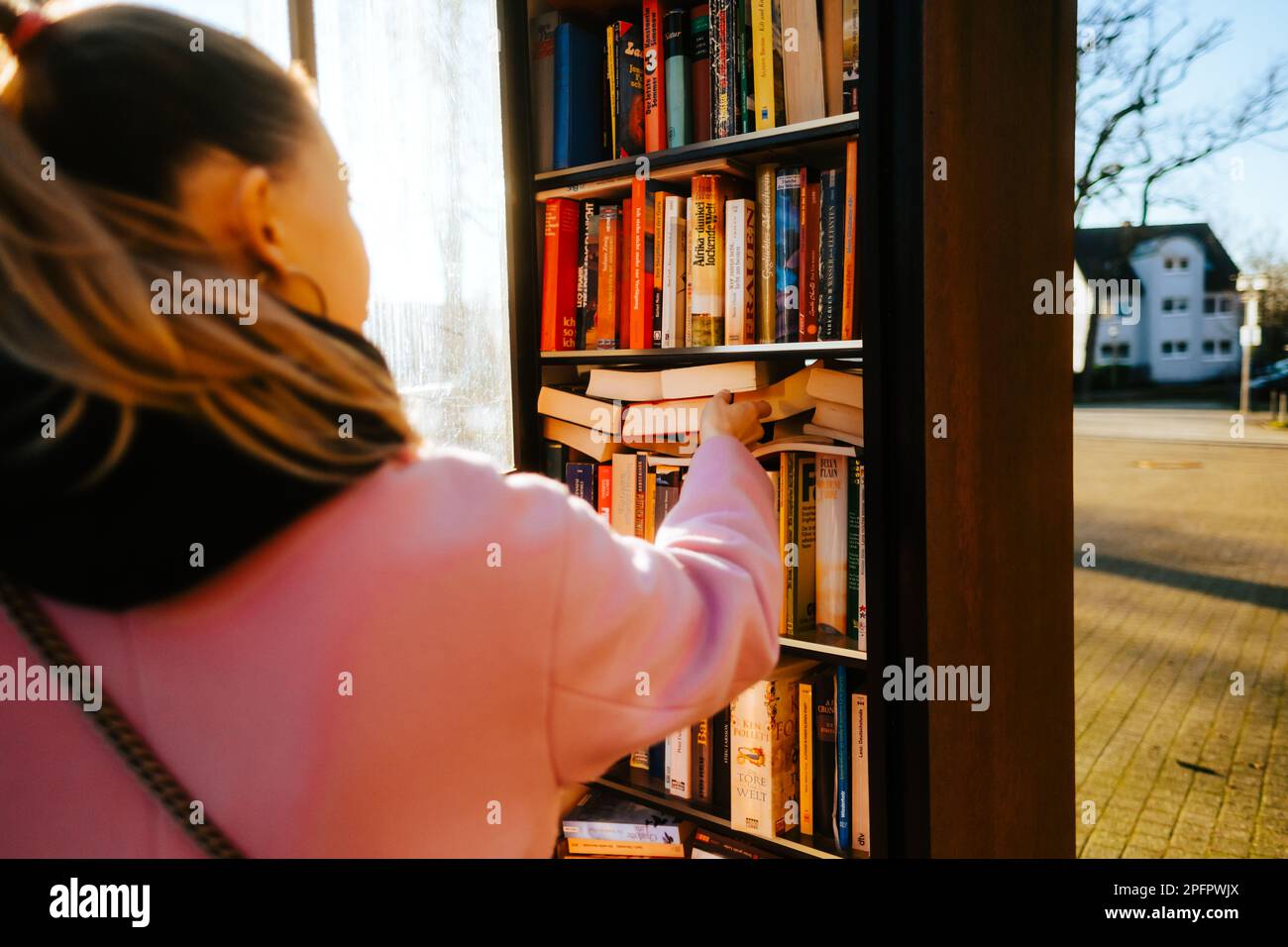 Young caucasian woman choosing books at free open public library at ...