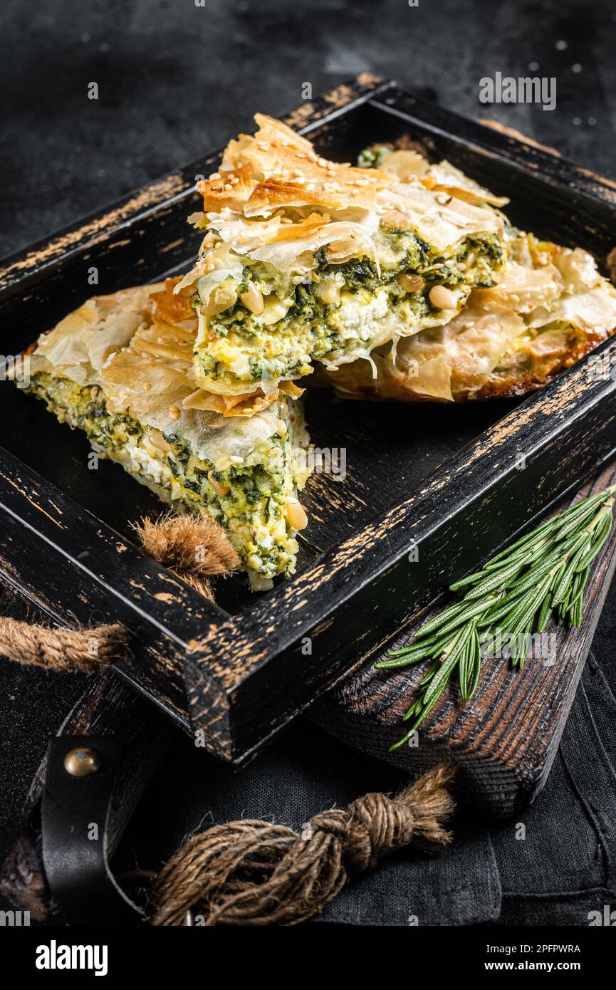 Spinach pie pieces, Spanakopita Greek Pie in wooden tray. Black ...