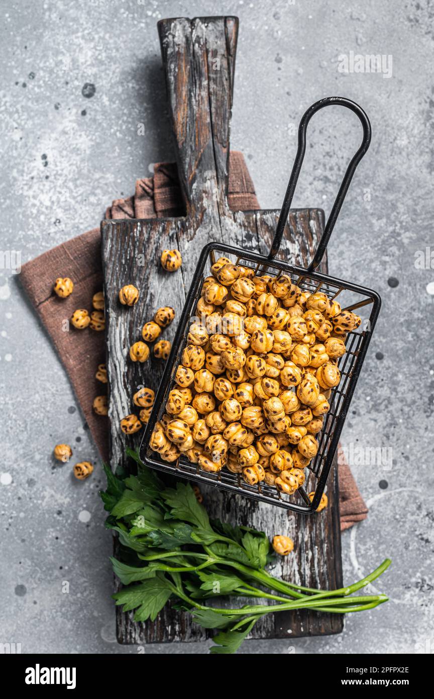 Healthy snack roasted spicy chickpeas in a basket. Gray background. Top ...