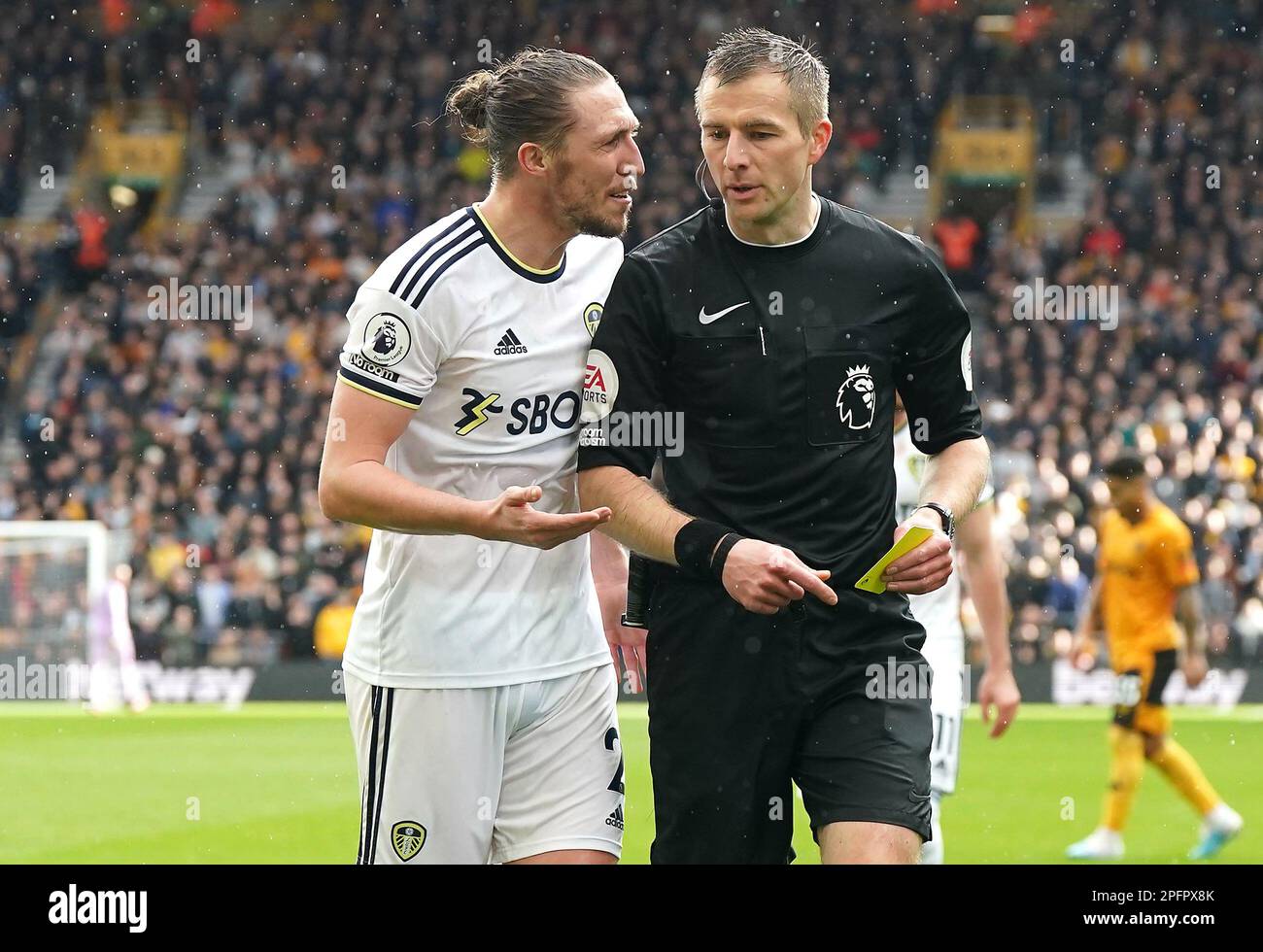 Referee Michael Salisbury (right) shows a yellow card to Leeds United's ...