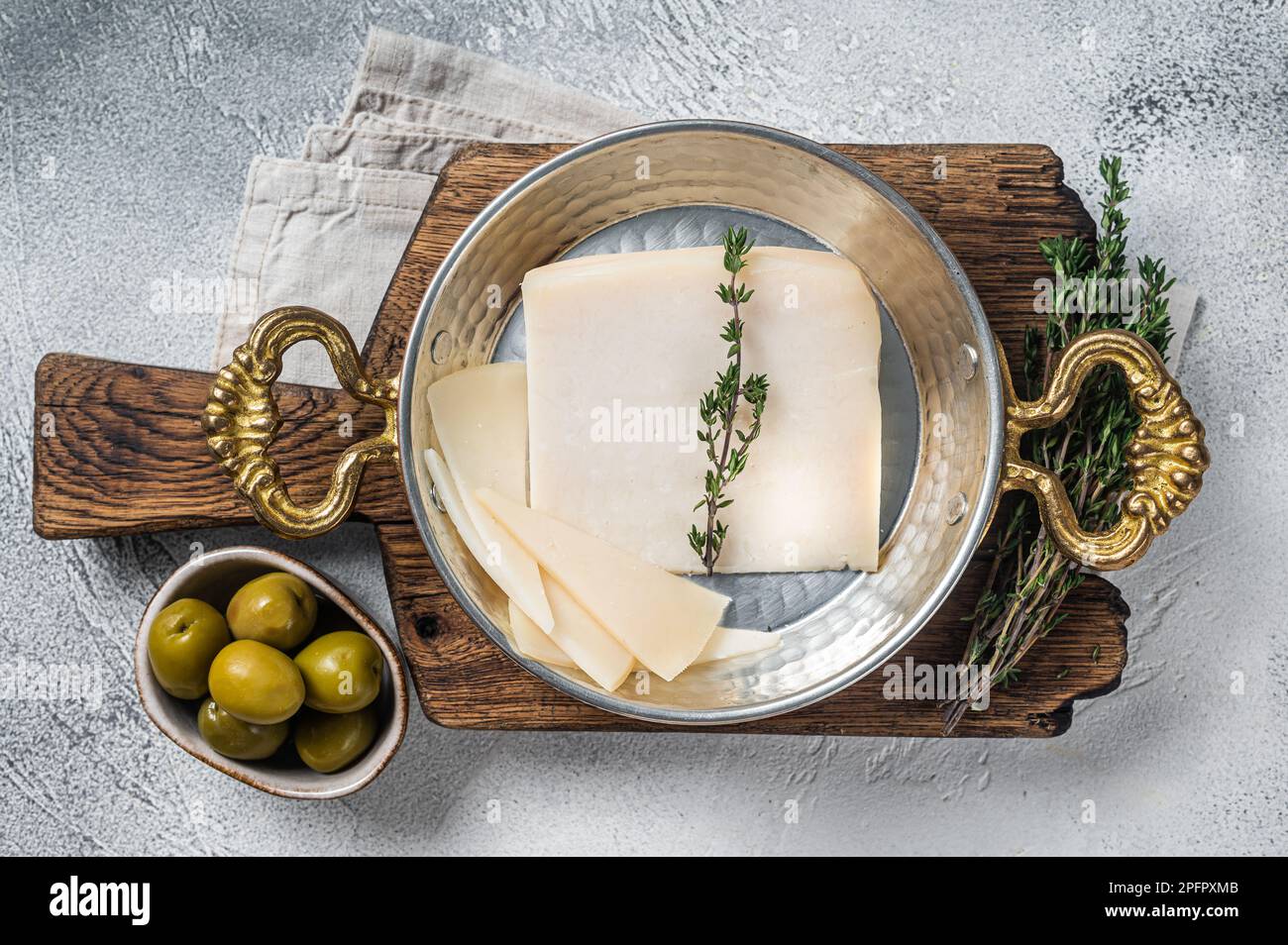 French hard goat cheese in a skillet with herbs. White background. Top ...