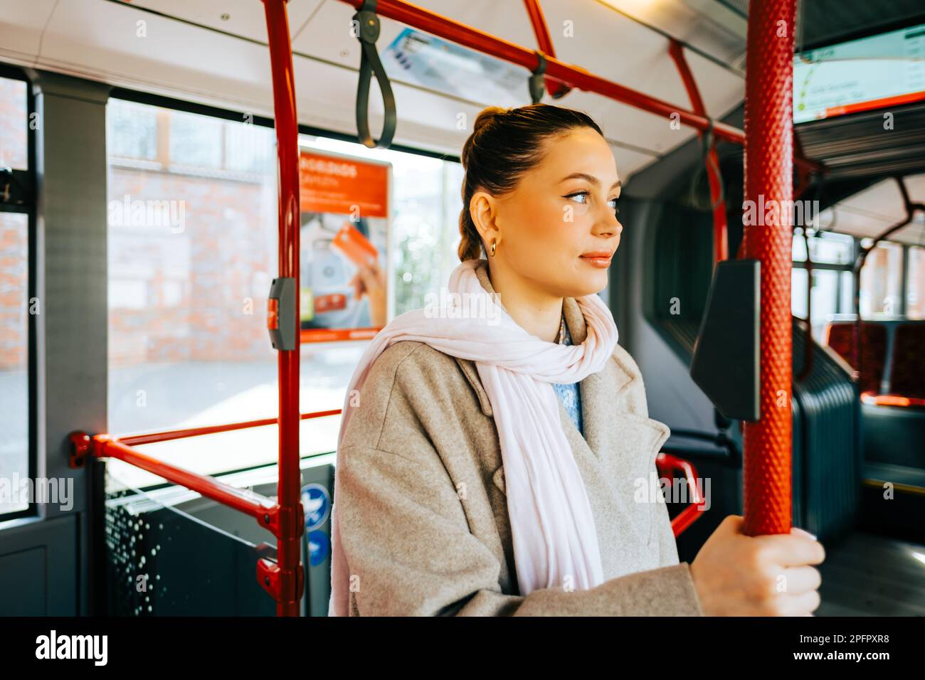 An attractive caucasian woman riding in a bus in the sunny day. Young ...