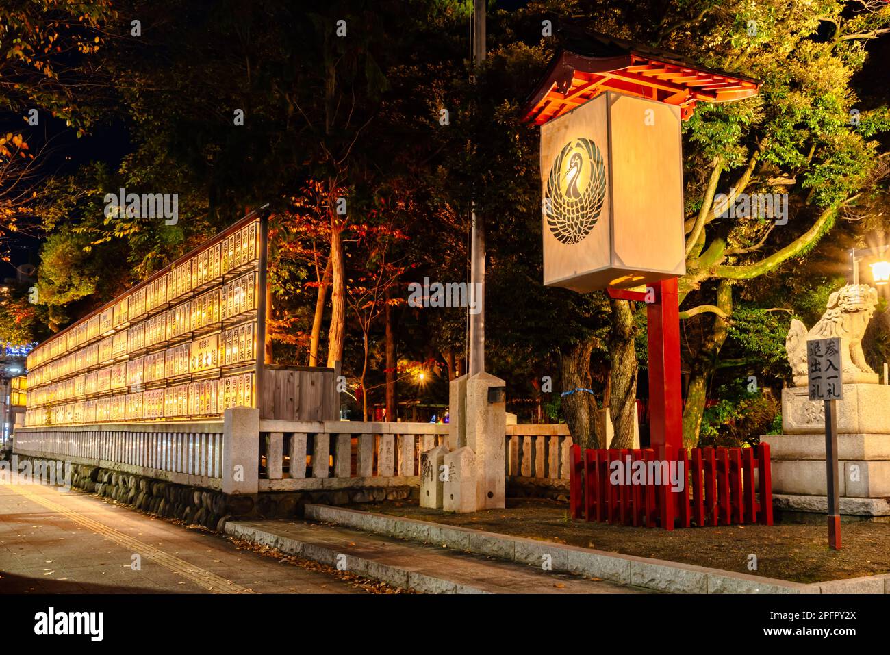 The sidewalk leading to the shrine is lined with a stone fence that has ...