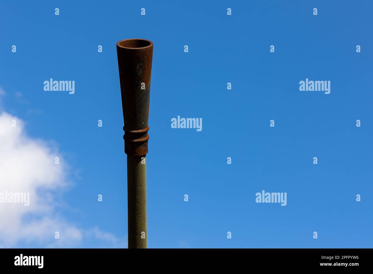 The muzzle of an anti-aircraft gun against the blue sky. Elements of ...