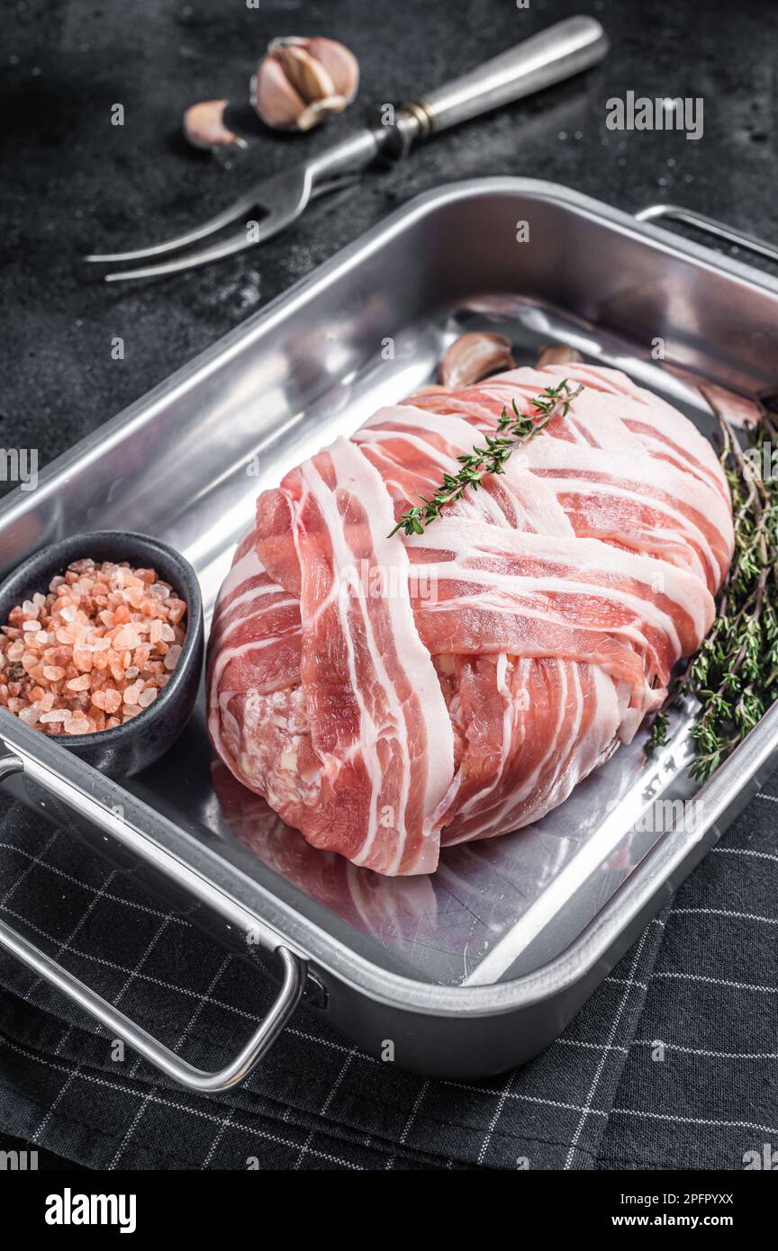 Cooking raw meatloaf with ground beef meat and bacon in steel tray ...