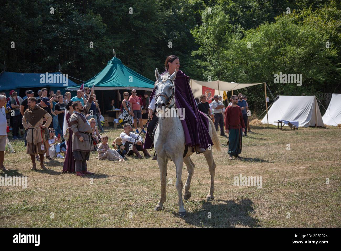 A woman in a cape riding a horse Stock Photo - Alamy
